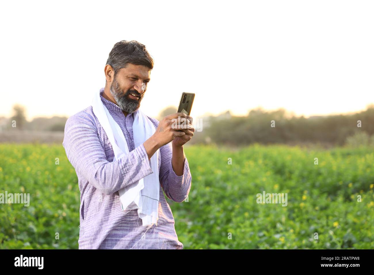 Happy Indian farmer feeling the wind while standing in the field ...