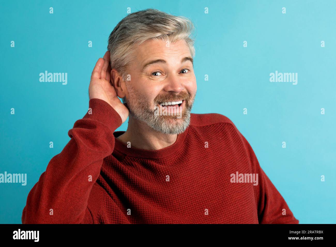 Middle aged man smiling with hand over ear, blue background Stock Photo ...