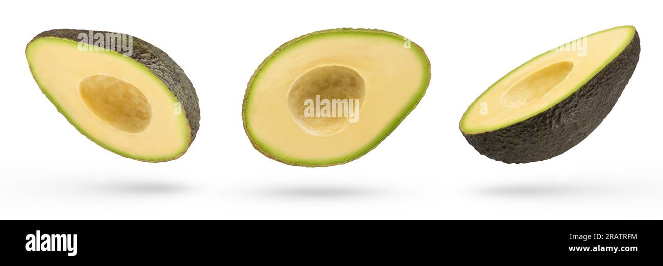 Flying fruits. Avocado halves on a white isolated background. An ...