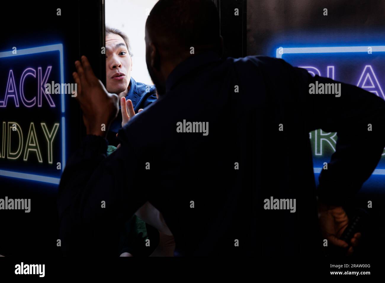 Young Asian guy trying to get inside of retail store on Black Friday ...
