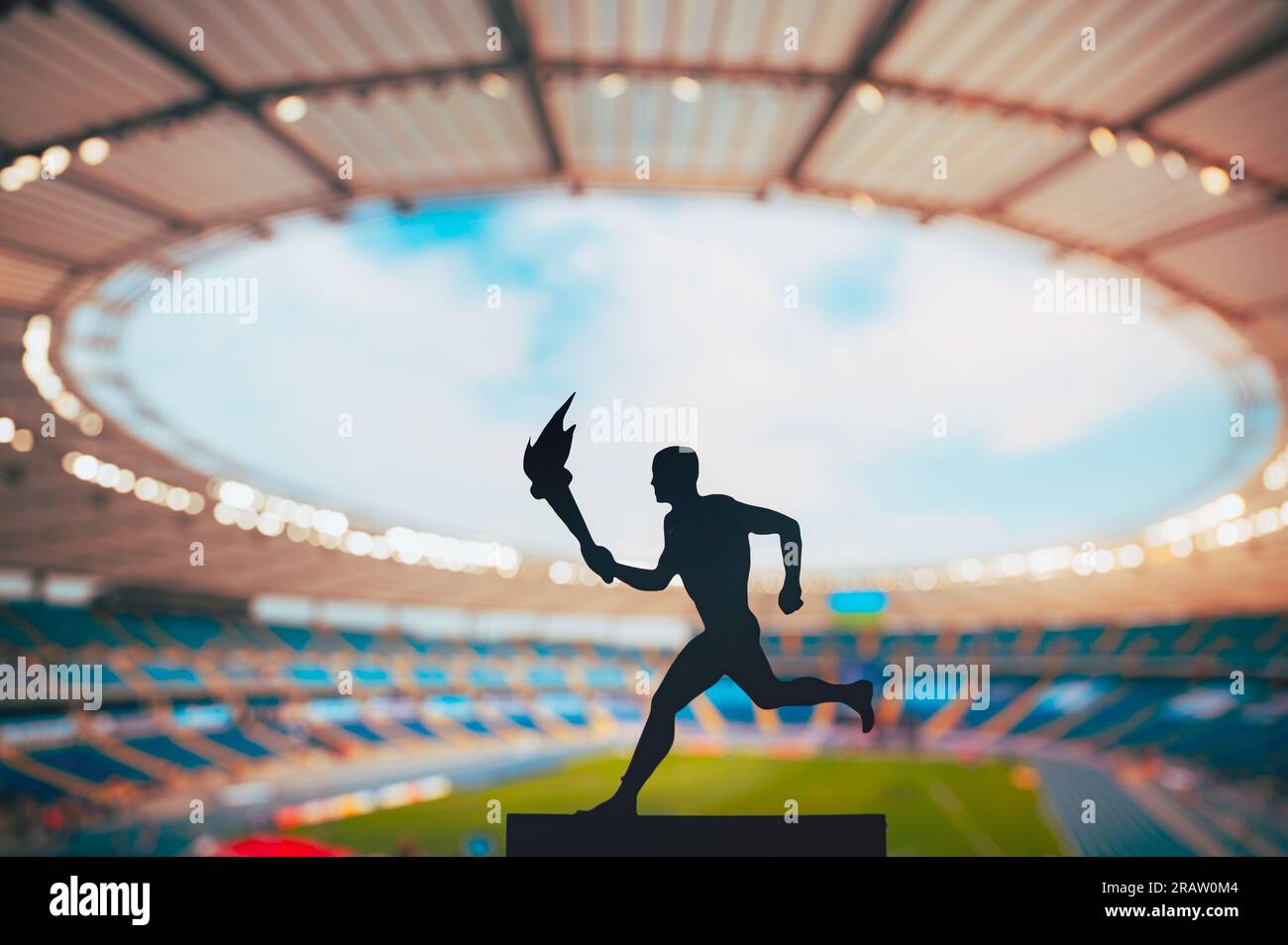 Silhouette of male athlete holding torch relay. Modern Track and Field ...
