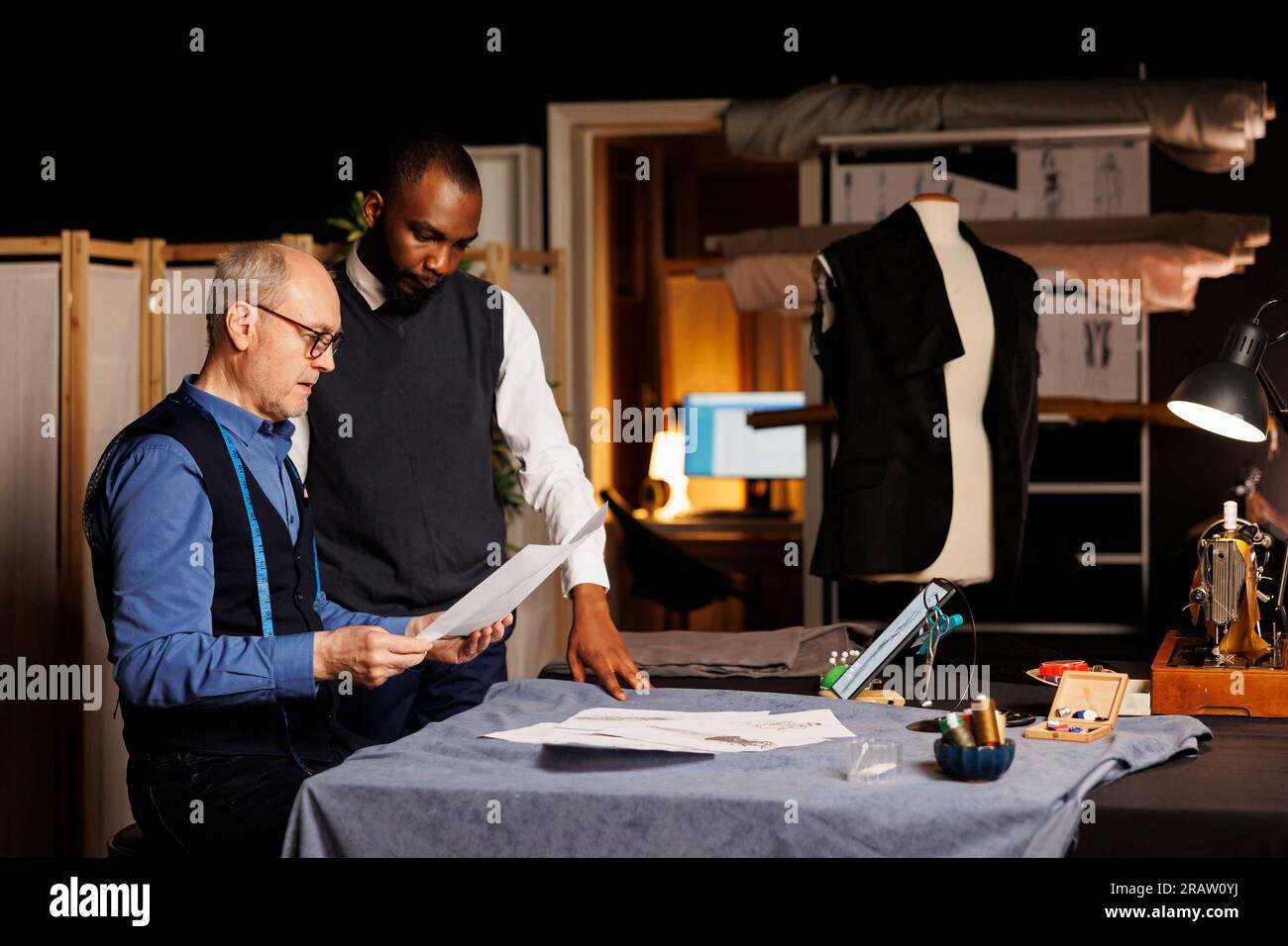 Skilled tailors comparing different fashion sketches attire ...