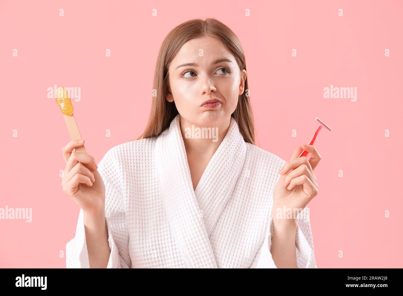 Thoughtful young woman choosing between shaving and sugaring on pink ...