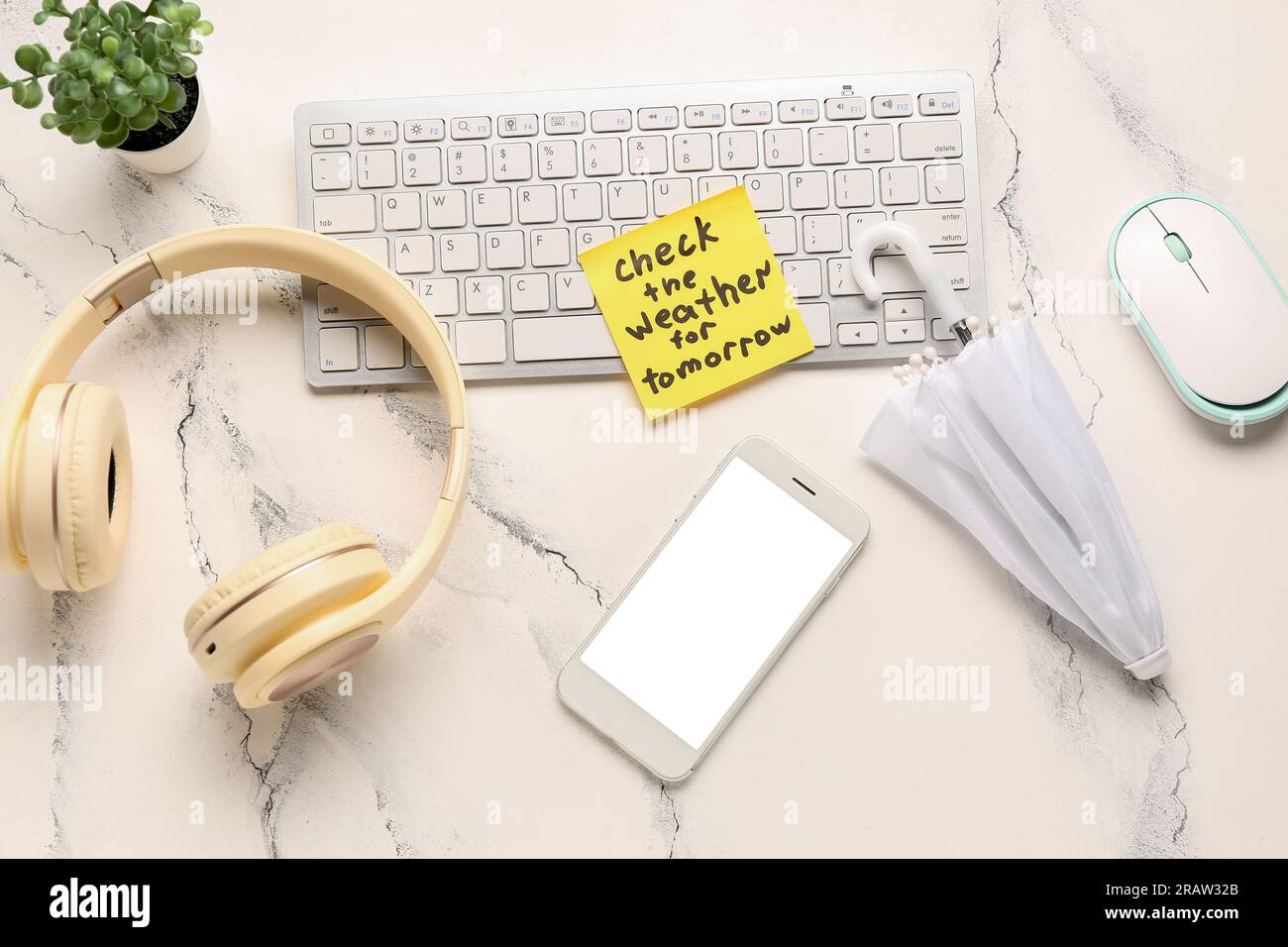 Sticky note with text CHECK THE WEATHER FOR TOMORROW, headphones ...