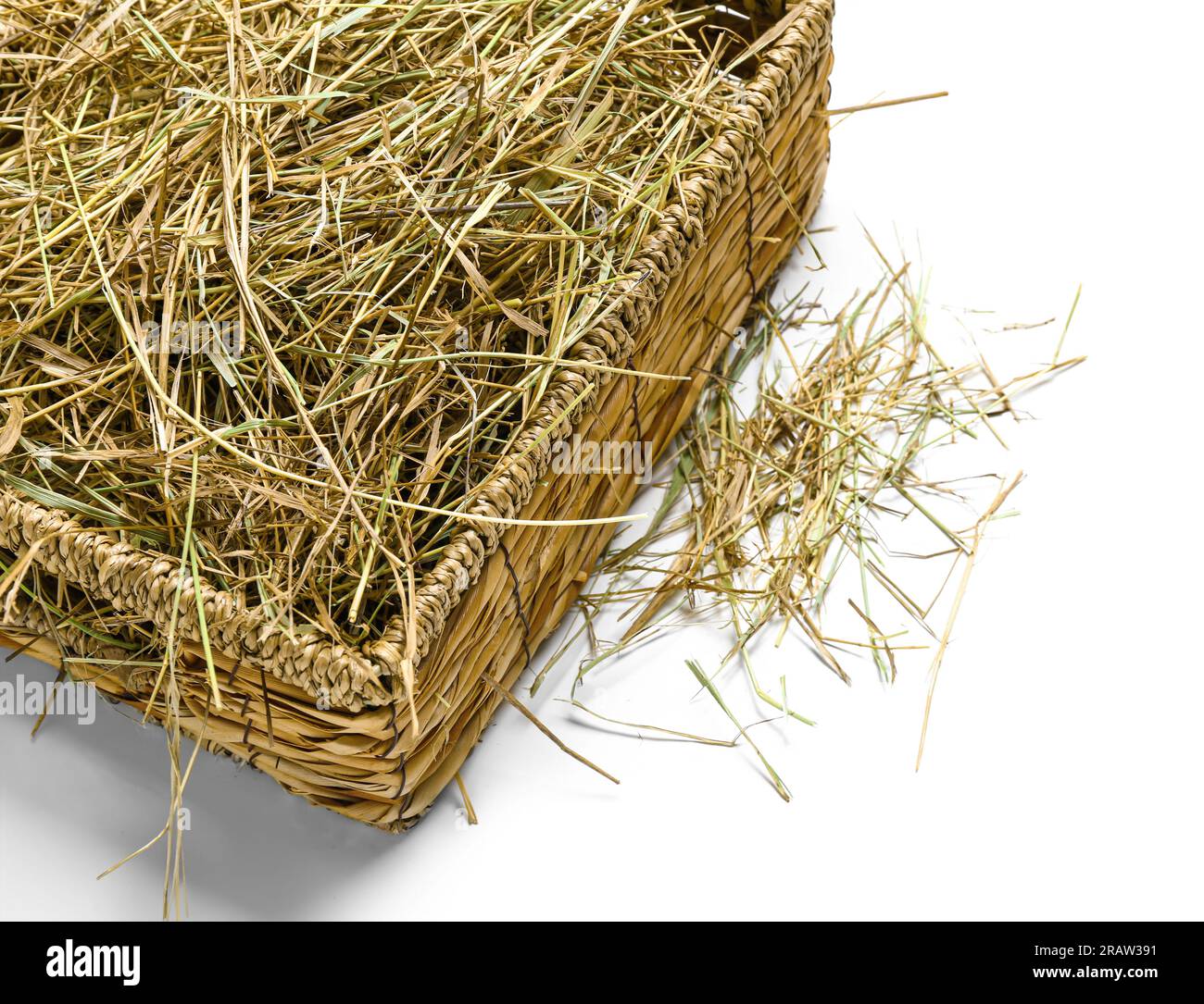 Straw in basket on white background Stock Photo - Alamy