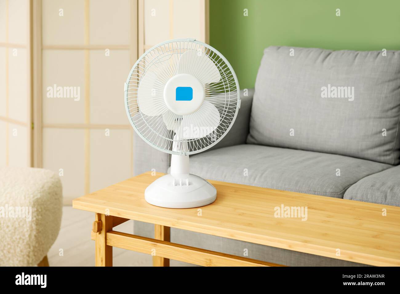 Wooden table with modern electric fan in interior of living room Stock ...