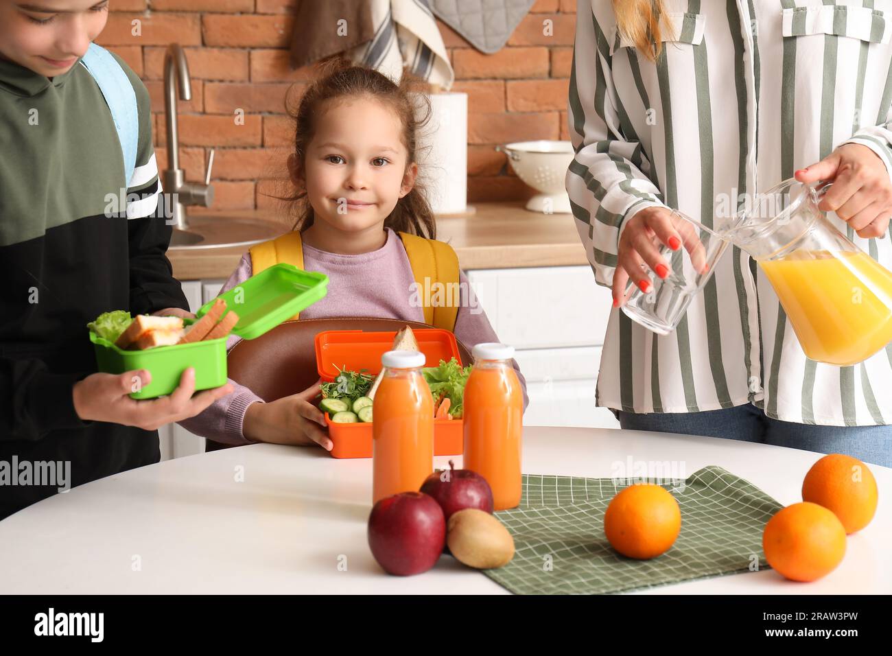 Little children with school lunch and their mother in kitchen Stock ...