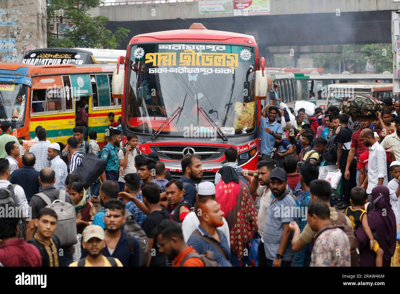 Passengers gather at a bus stand as they go home ahead of the Muslim ...