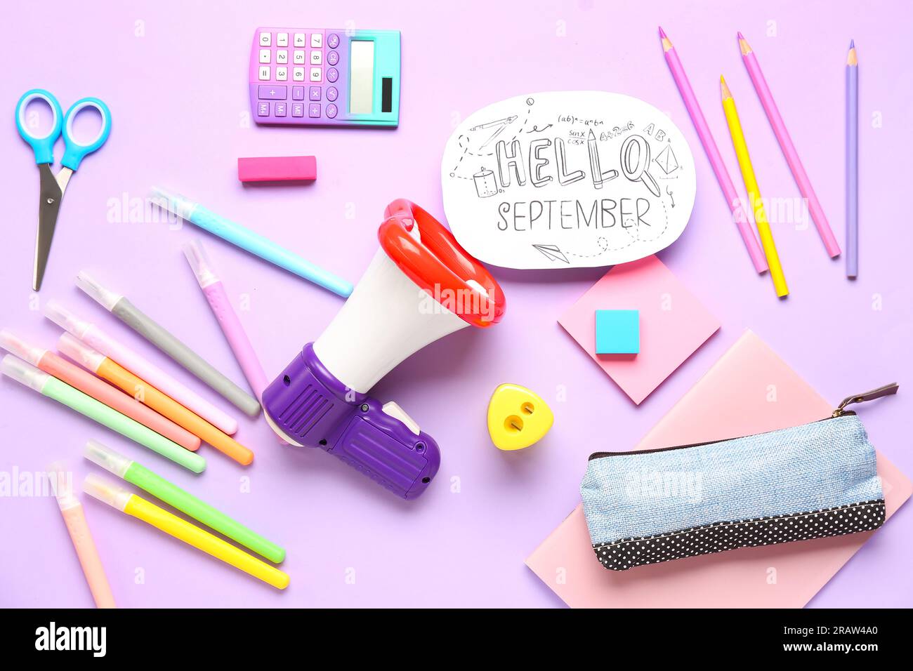 Stationery, megaphone and sheet with text HELLO SEPTEMBER on lilac ...