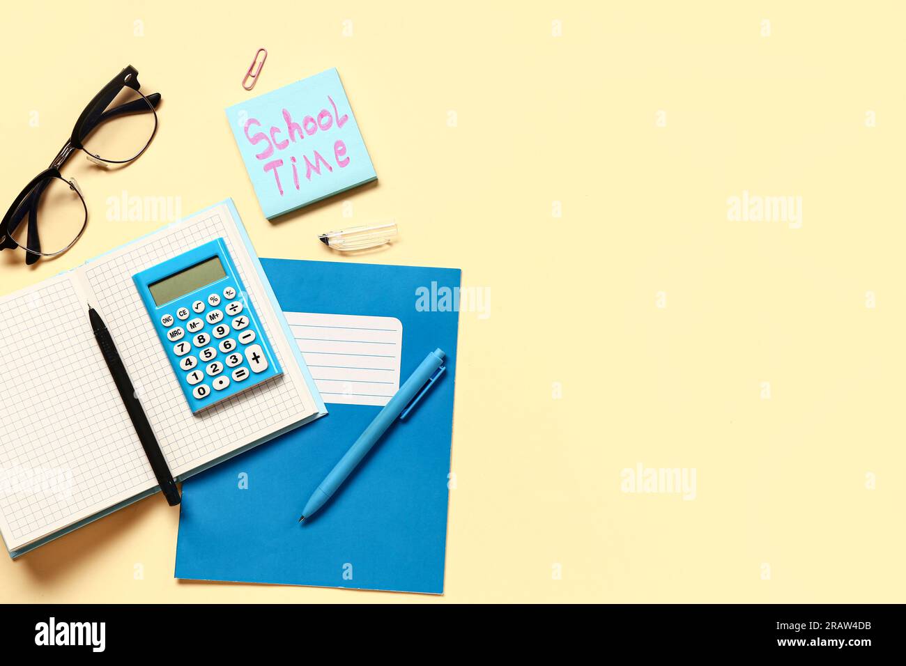 Sticky note with text SCHOOL TIME, stationery and calculator on pale ...