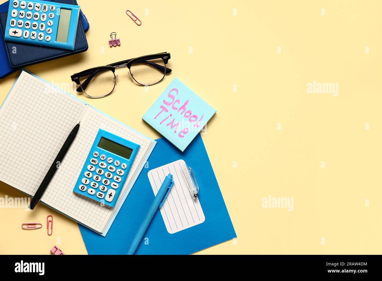 Sticky note with text SCHOOL TIME, stationery and calculator on pale ...