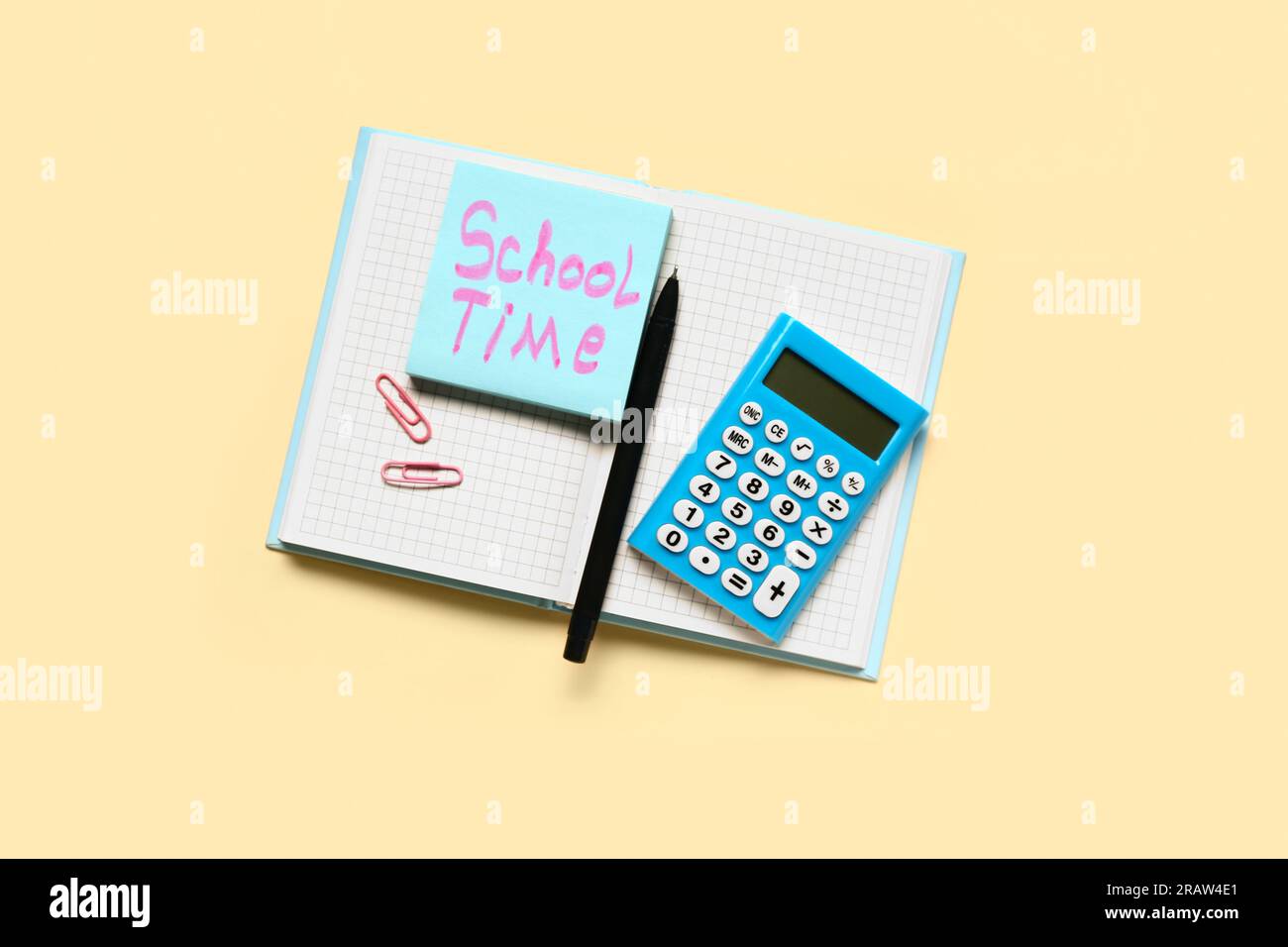 Sticky note with text SCHOOL TIME, stationery and calculator on pale ...