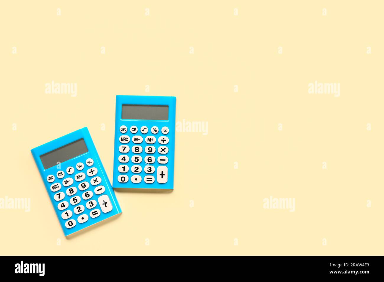 Modern calculators on pale yellow background Stock Photo - Alamy