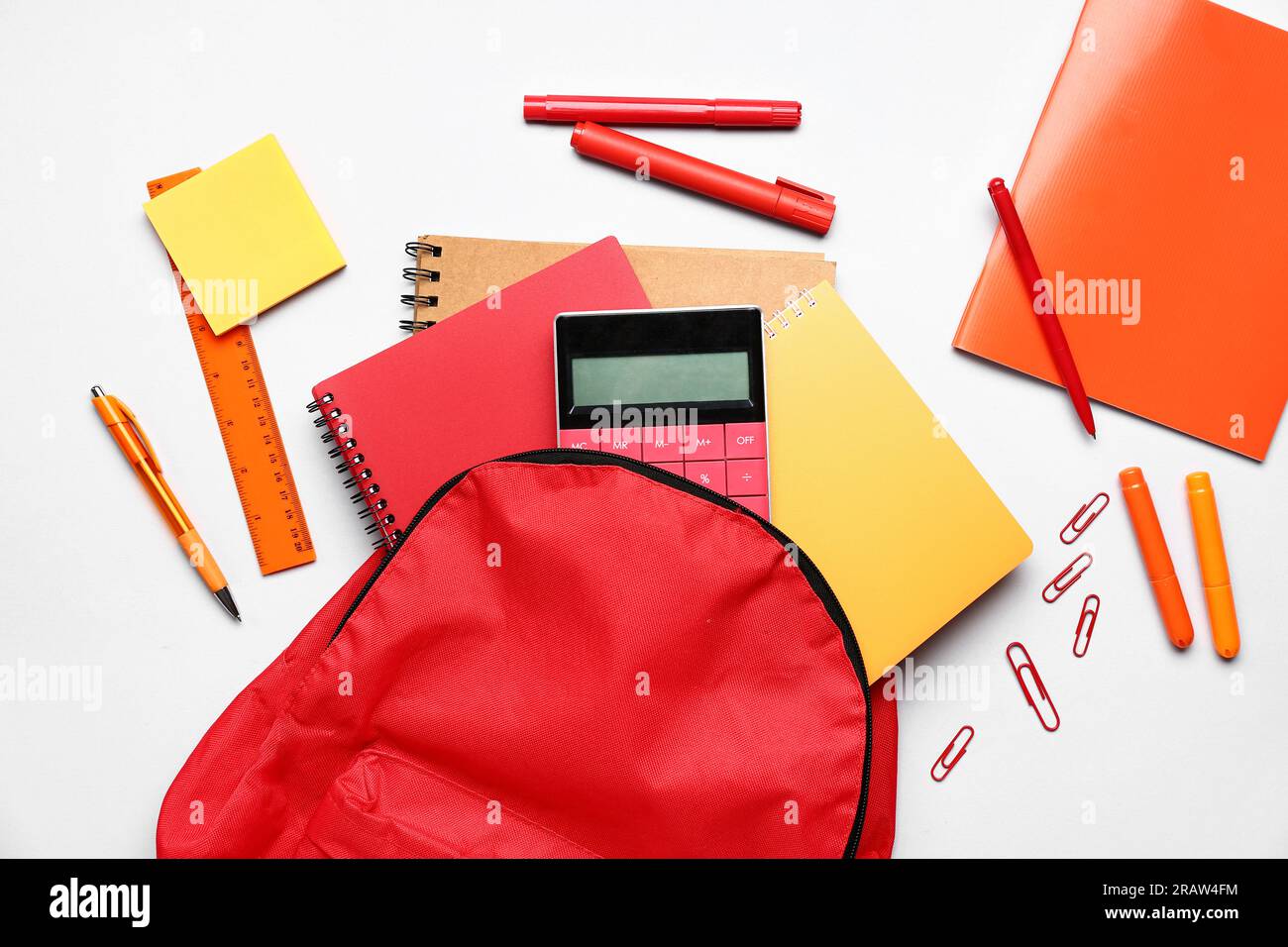 Backpack with calculator and different stationery on white background ...