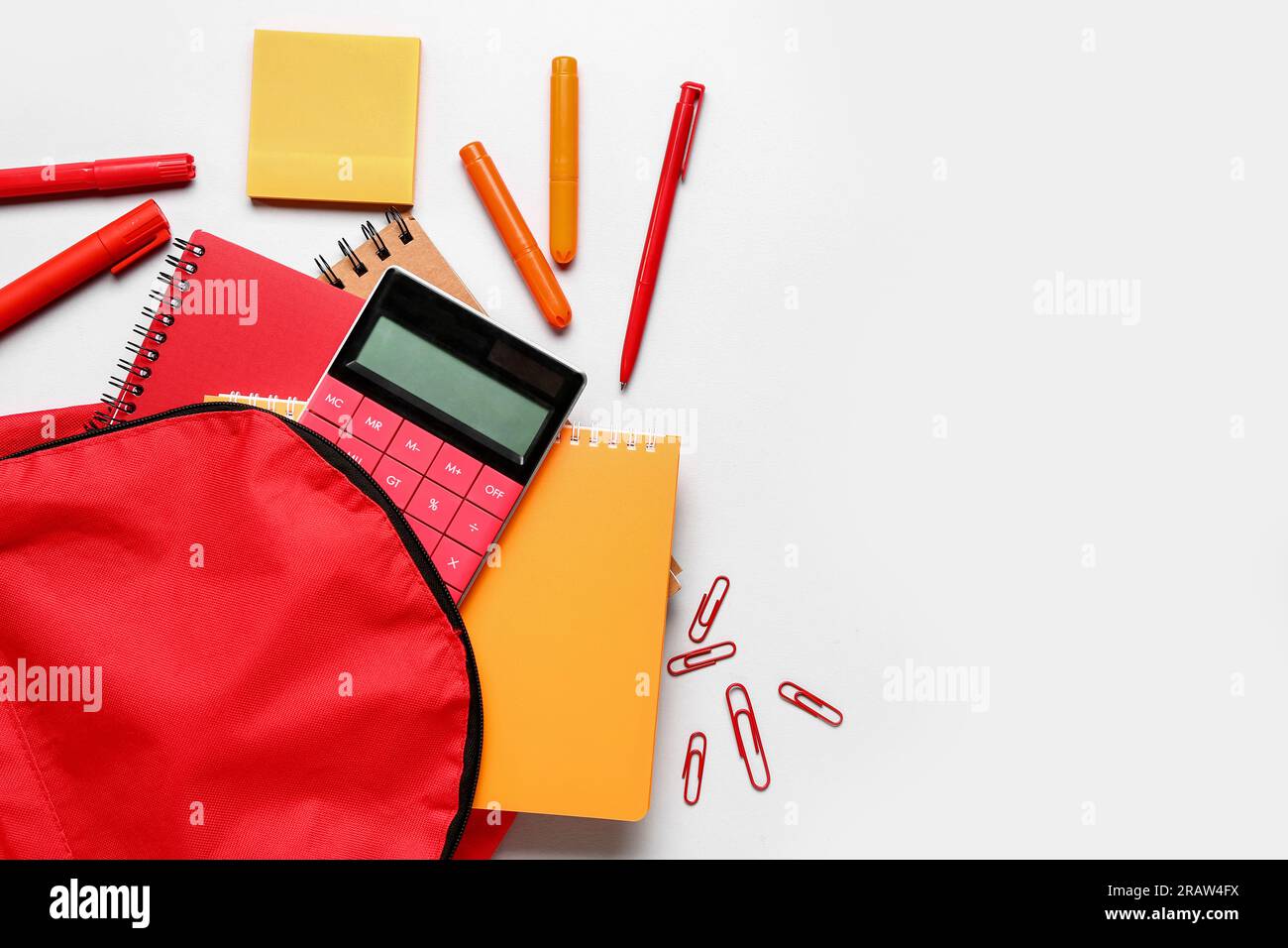 Backpack with calculator and different stationery on white background ...