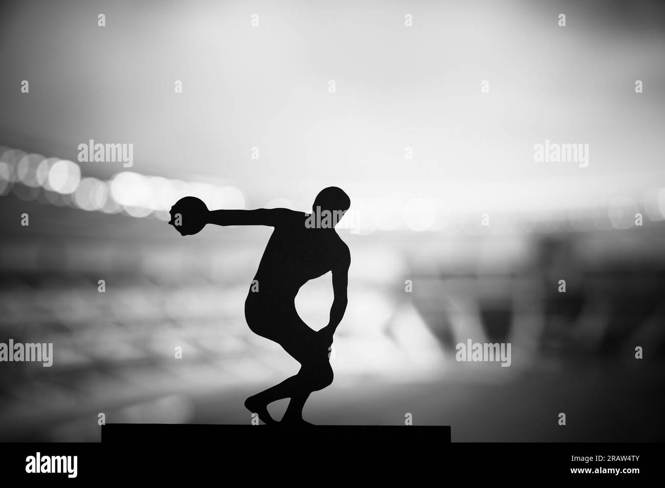 Silhouette of Athlete, Launching the Discus amidst Ethereal Evening ...