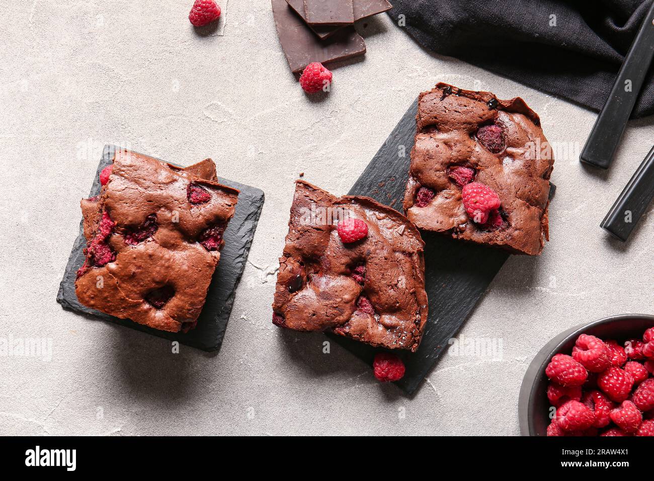 Boards with pieces of raspberry chocolate brownie on grey table Stock ...