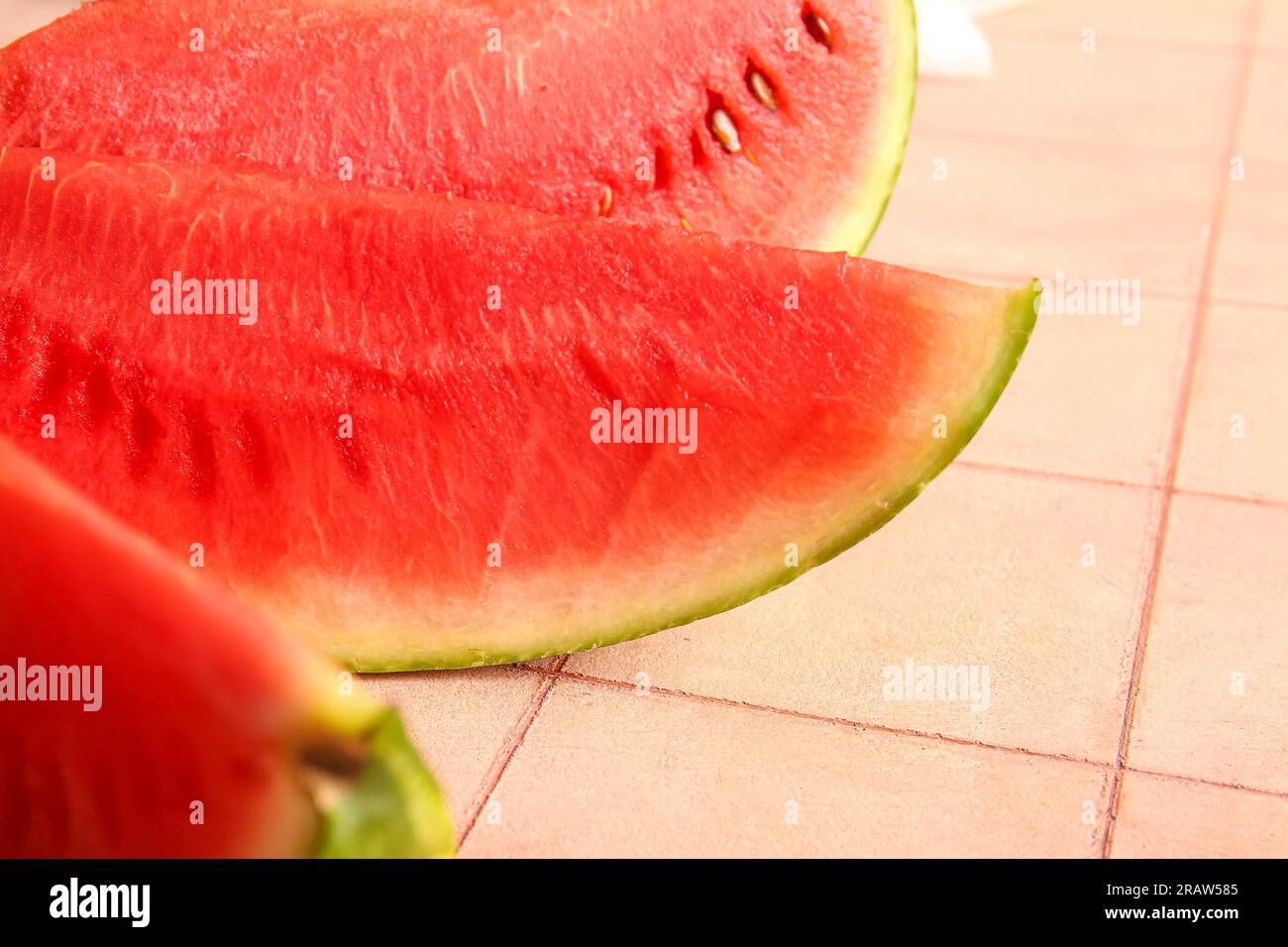 Pieces of fresh watermelon on pink tile table Stock Photo - Alamy