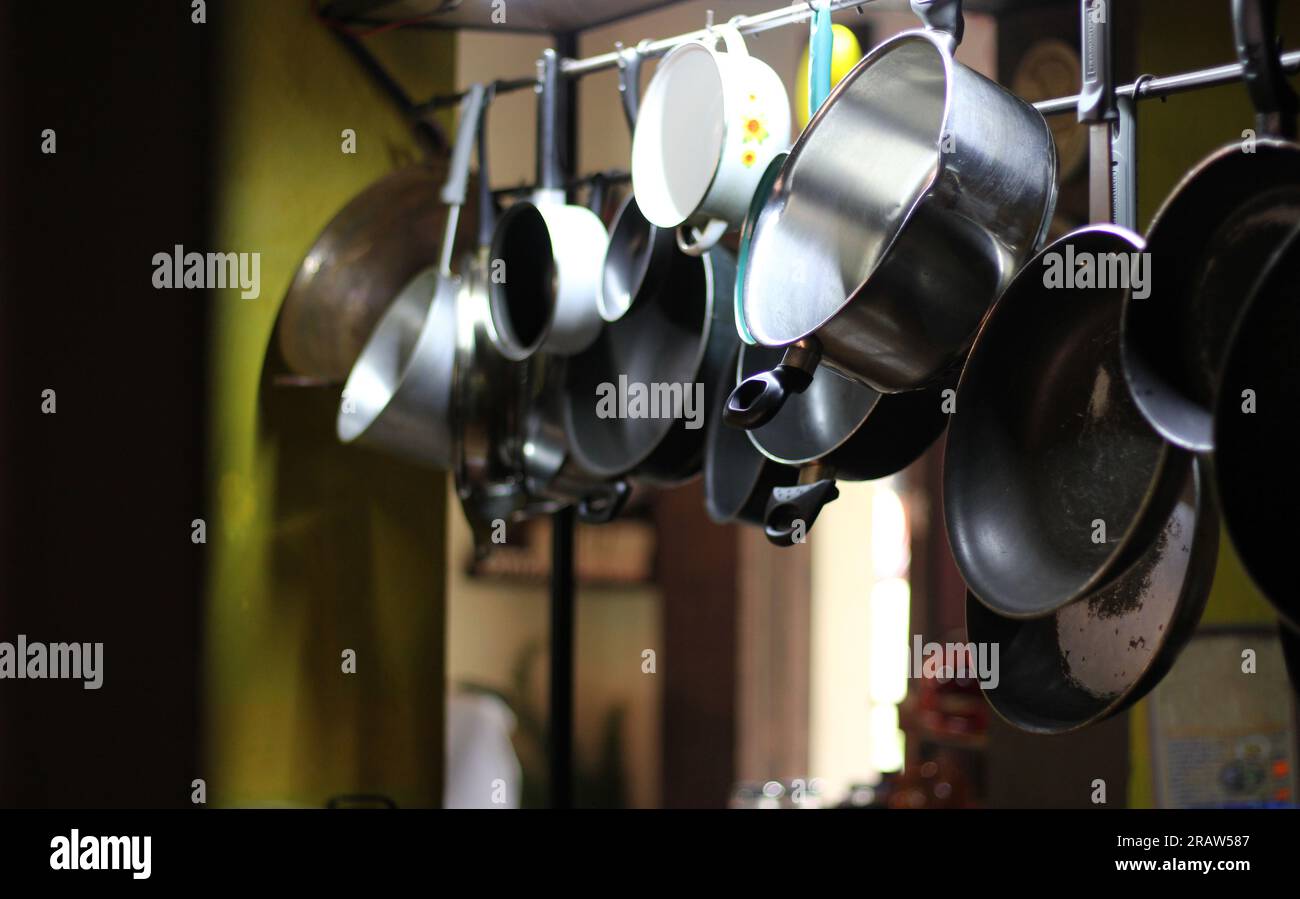 View of hanging pots, pans and kitchen utensils with bokeh effect Stock ...
