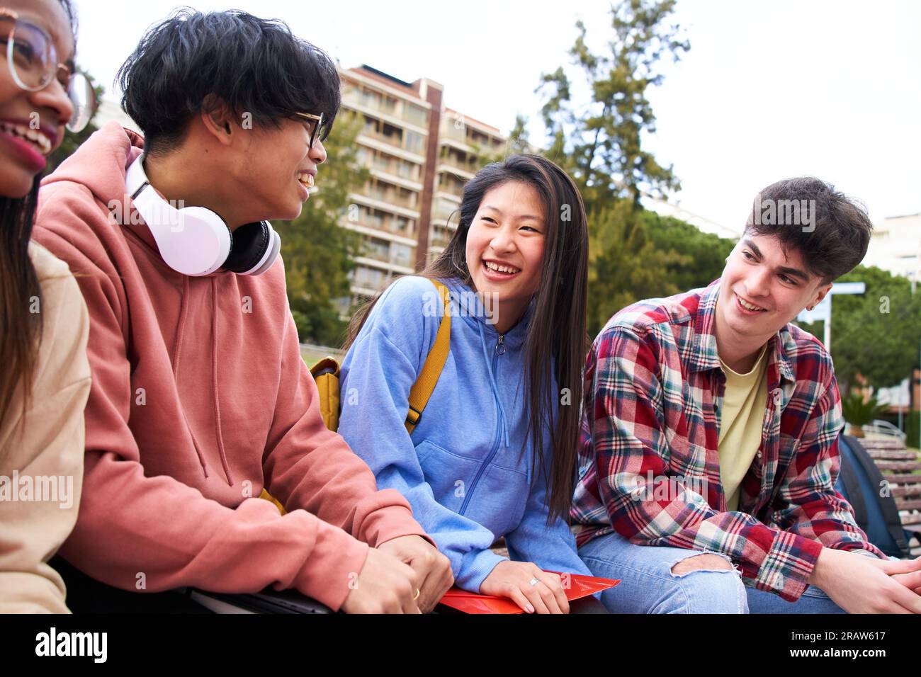 Group of four students laugh a lot and have fun outdoors. Teenage gen z ...