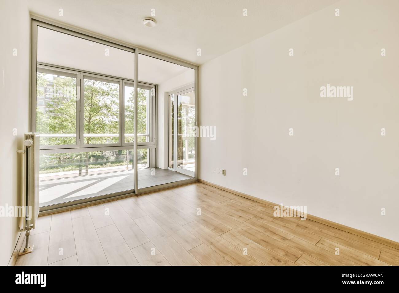an empty room with wood floors and large windows in the middle part of ...
