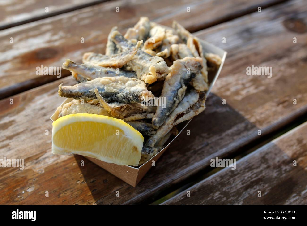 small fried fish with lemon at an outdoor seaside restaurant Stock ...