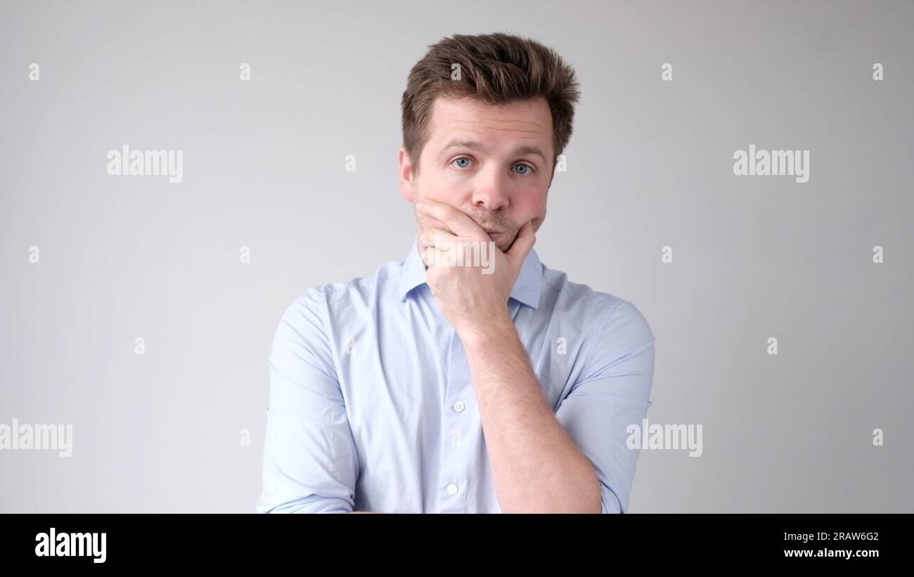 man is looking thoughtfully into the camera, perplexed by a difficult ...