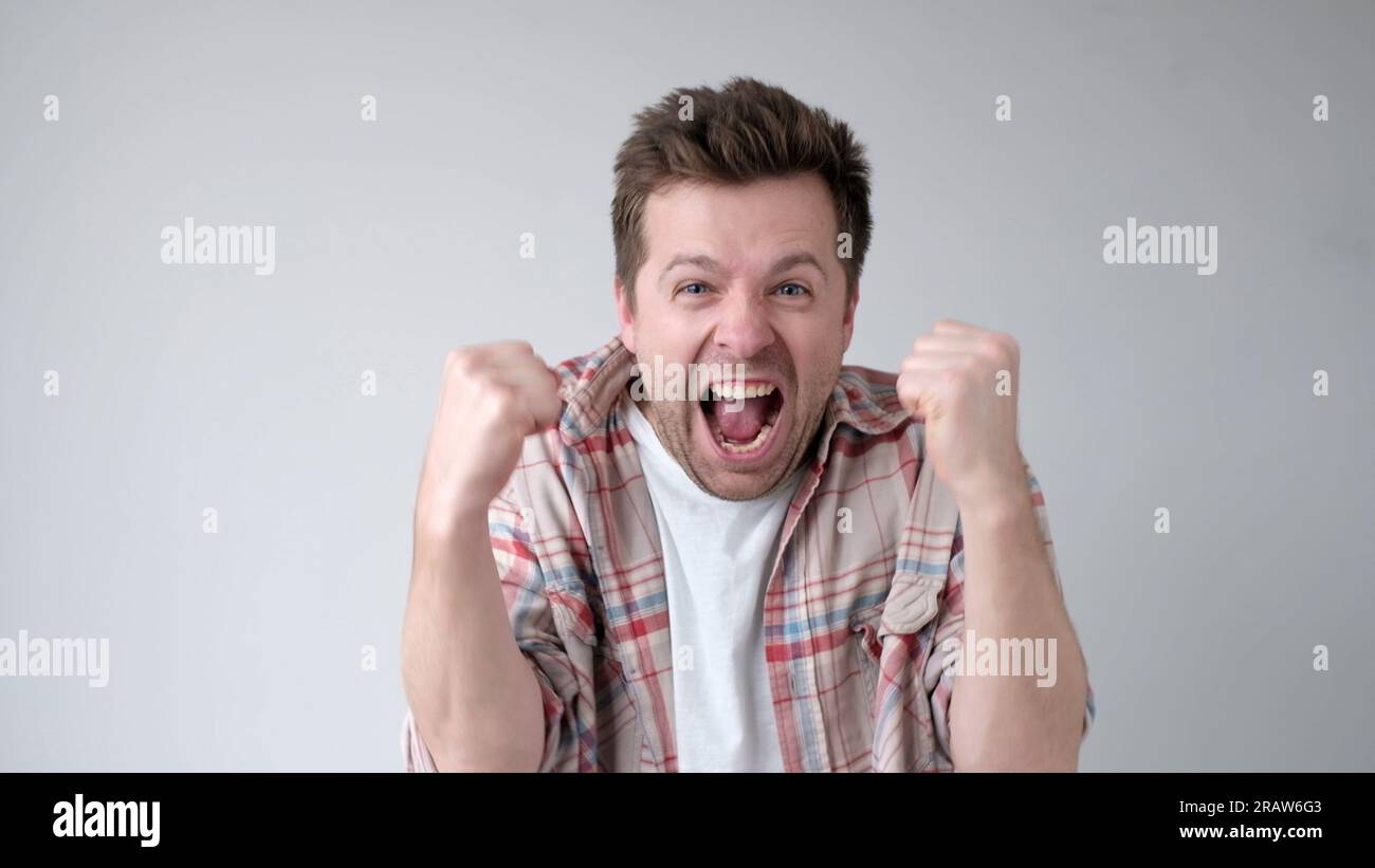 man in awe clenches his fists and shouts yes Stock Photo - Alamy