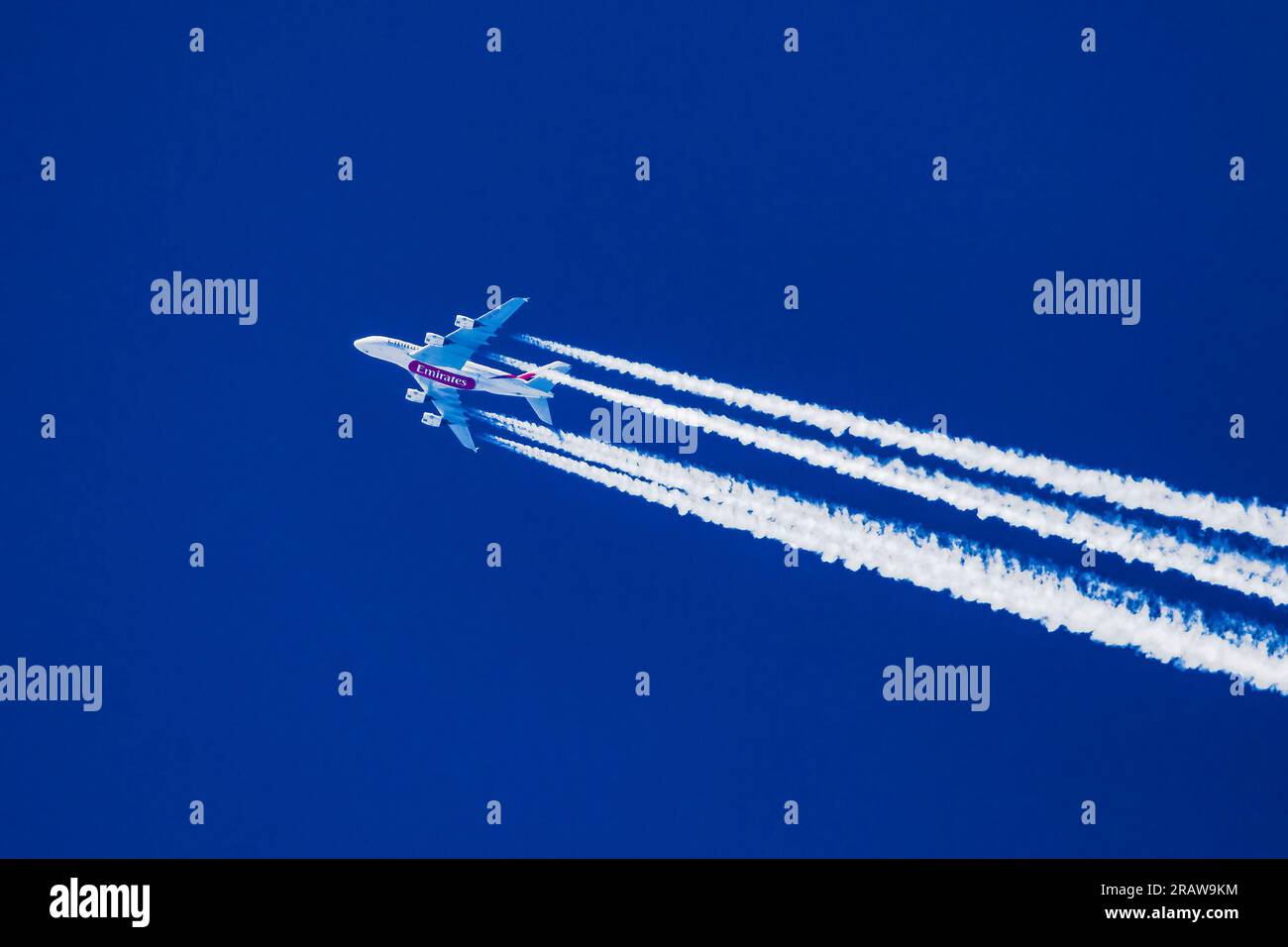 Sharp telephoto close-up of jet plane aircraft with contrails cruising ...