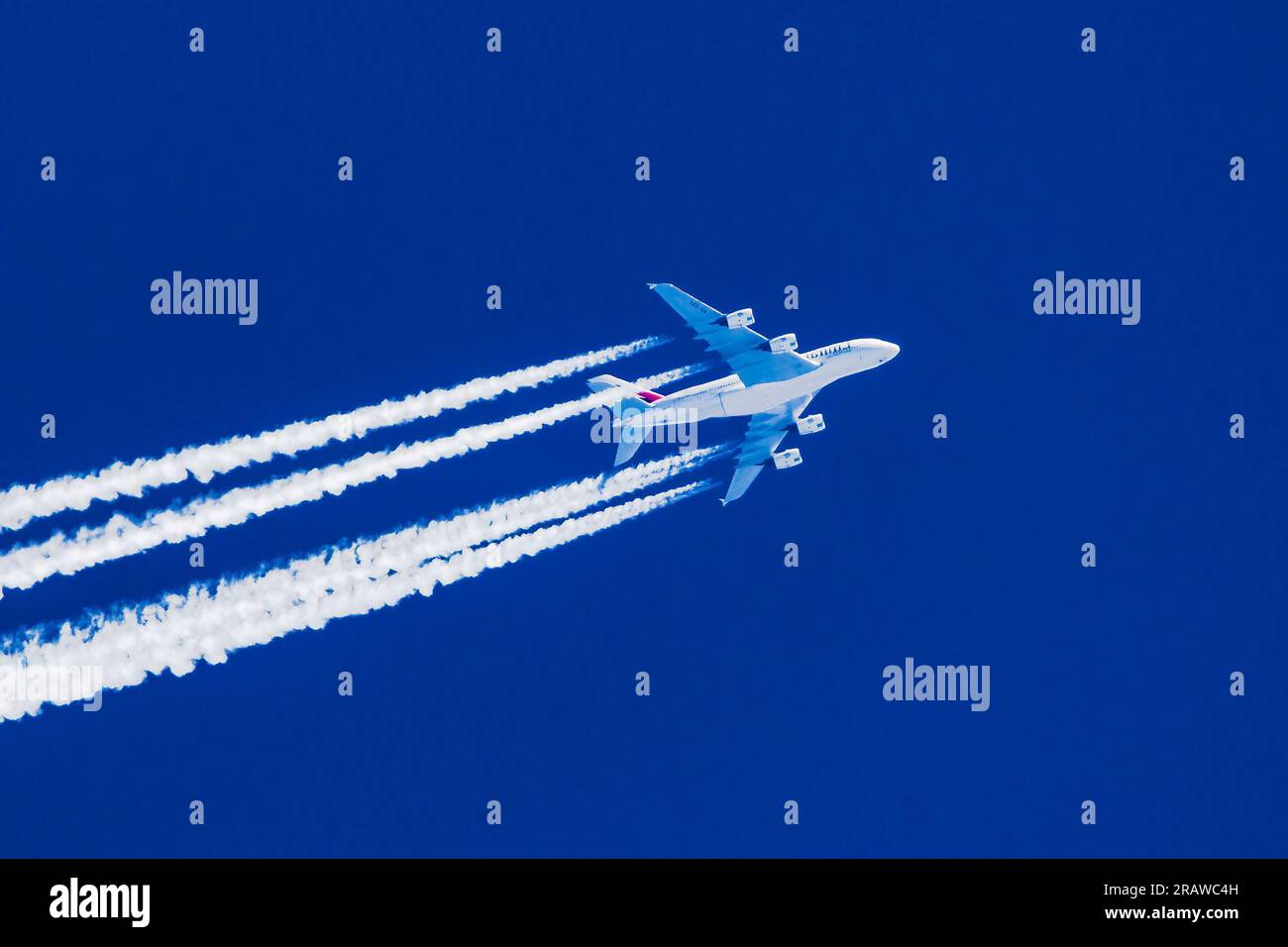 Sharp telephoto close-up of jet plane aircraft with contrails cruising ...