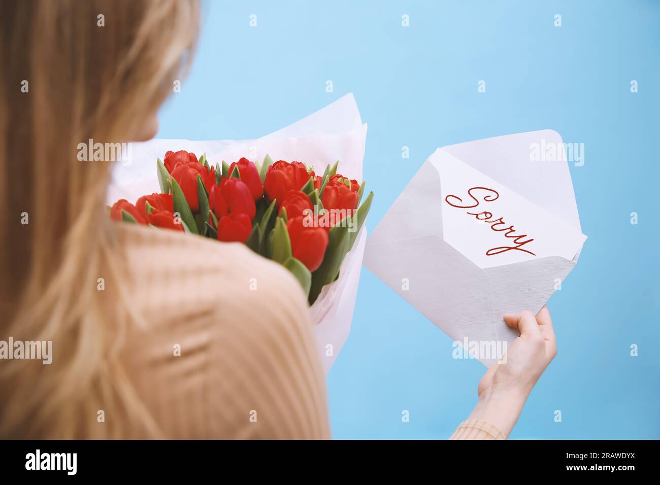 Apology. Woman holding Sorry greeting card and bouquet of tulips on ...