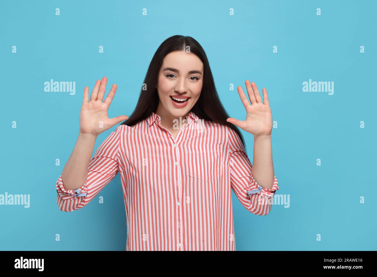 Happy woman giving high five with both hands on light blue background ...