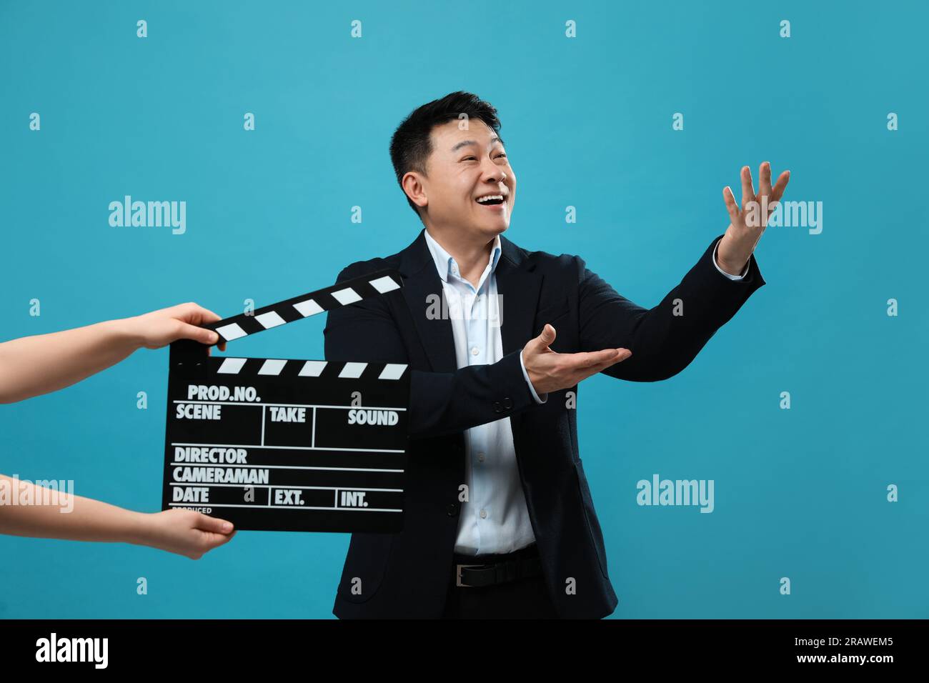 Happy asian actor performing while second assistant camera holding ...