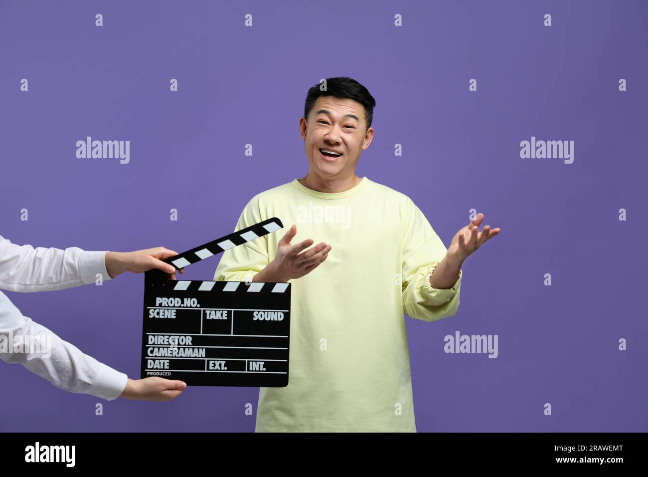 Happy asian actor performing while second assistant camera holding ...