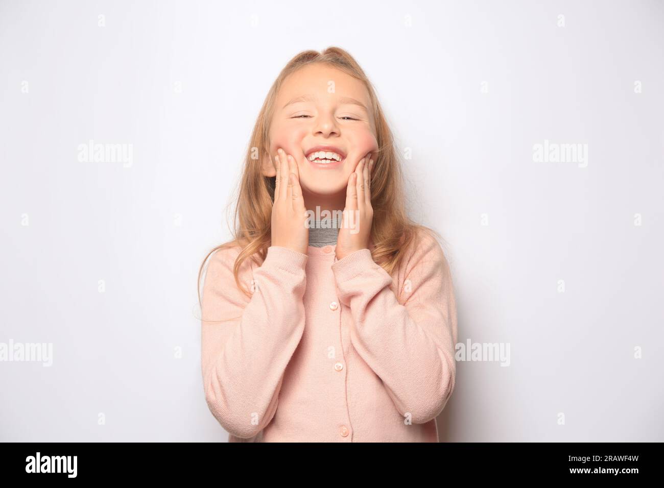 Happy little girl touching cheeks on white background Stock Photo - Alamy