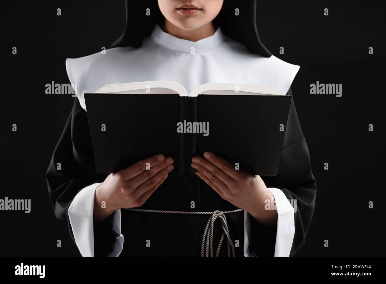 Nun reading Bible on black background, closeup Stock Photo - Alamy