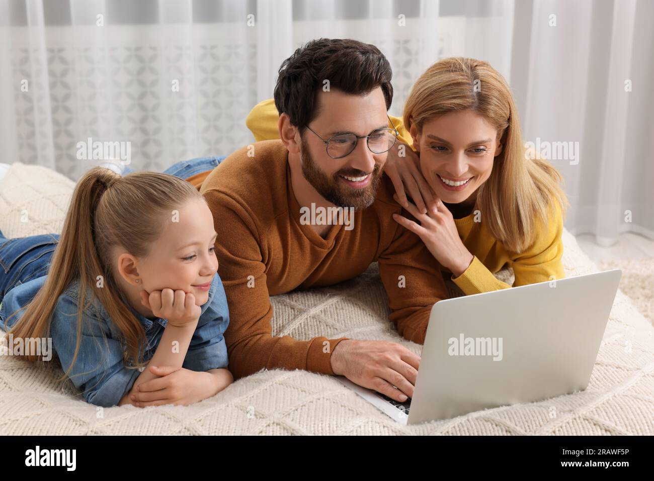 Happy family with laptop on bed at home Stock Photo - Alamy