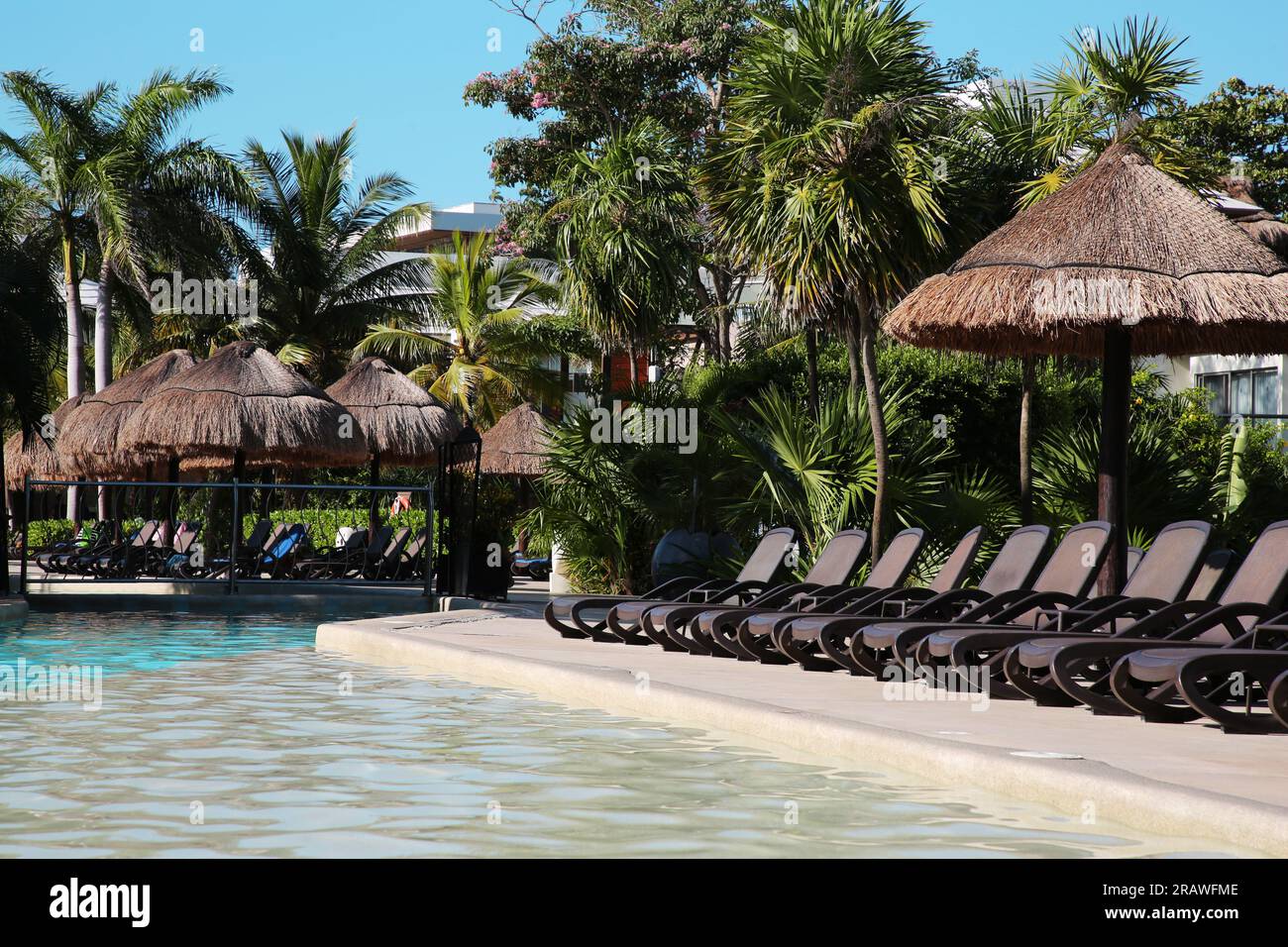Outdoor swimming pool with sunbeds at resort on sunny day Stock Photo ...