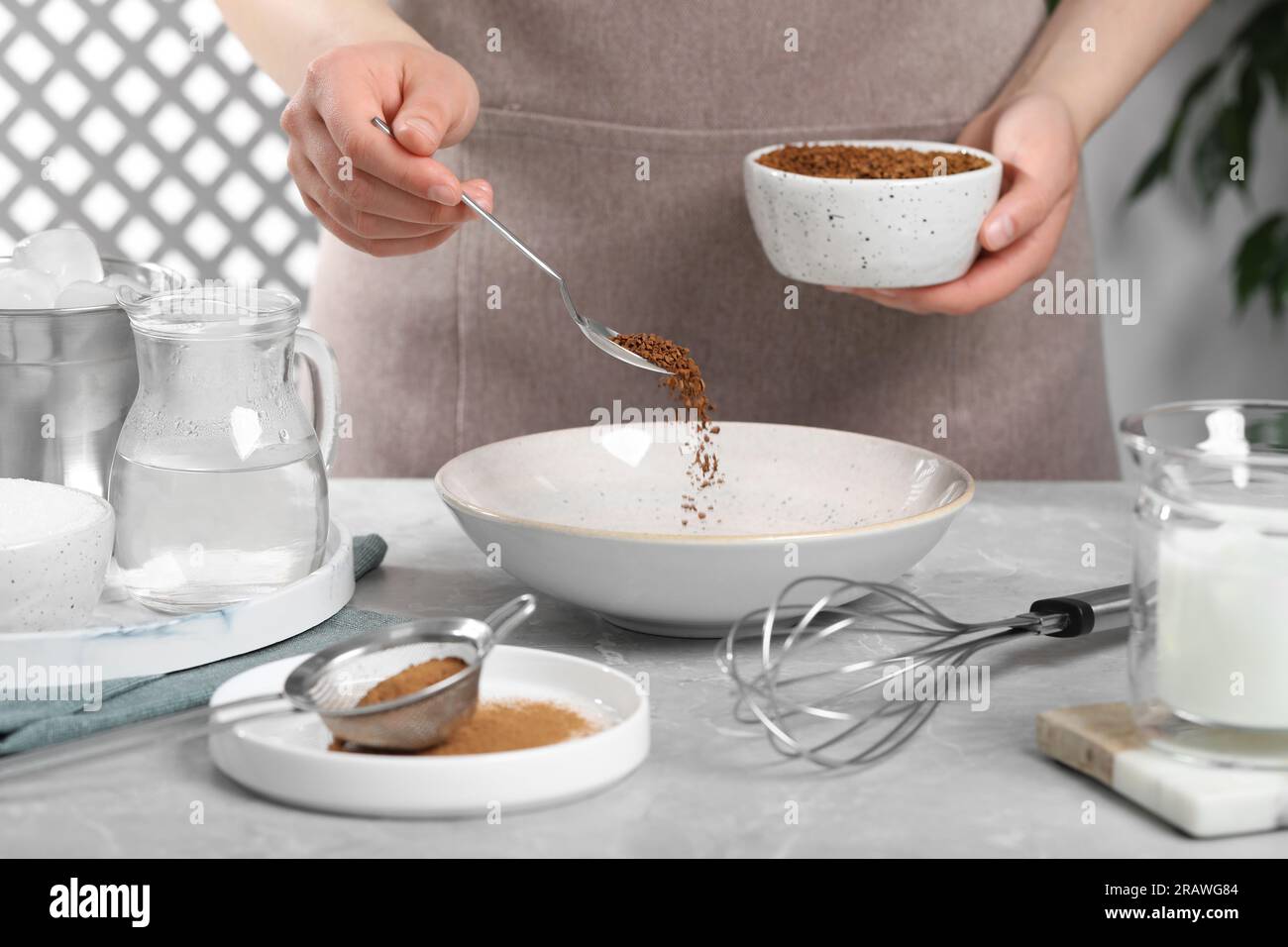 Making dalgona coffee. Woman pouring instant granules into bowl at ...