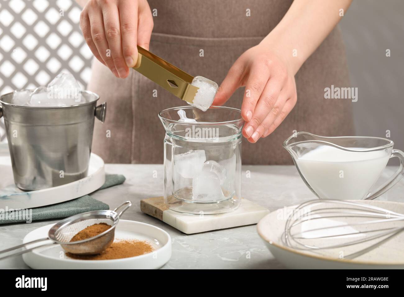 Making Dalgona Coffee Woman Putting Ice Cubes Into Glass At Light Gray