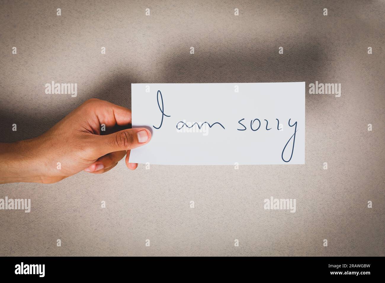 Apology. Man holding card with phrase I Am Sorry on grey background ...