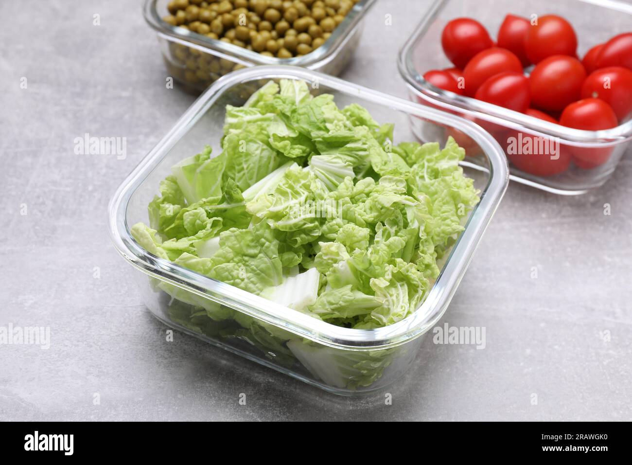 Glass containers with different fresh products on light grey table ...