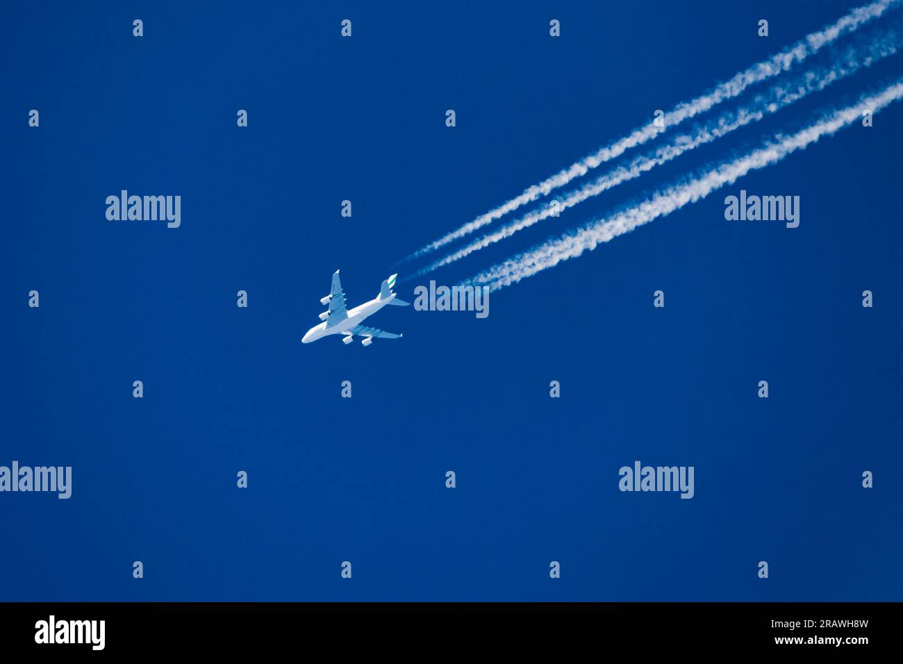 Sharp telephoto close-up of jet plane aircraft with contrails cruising ...