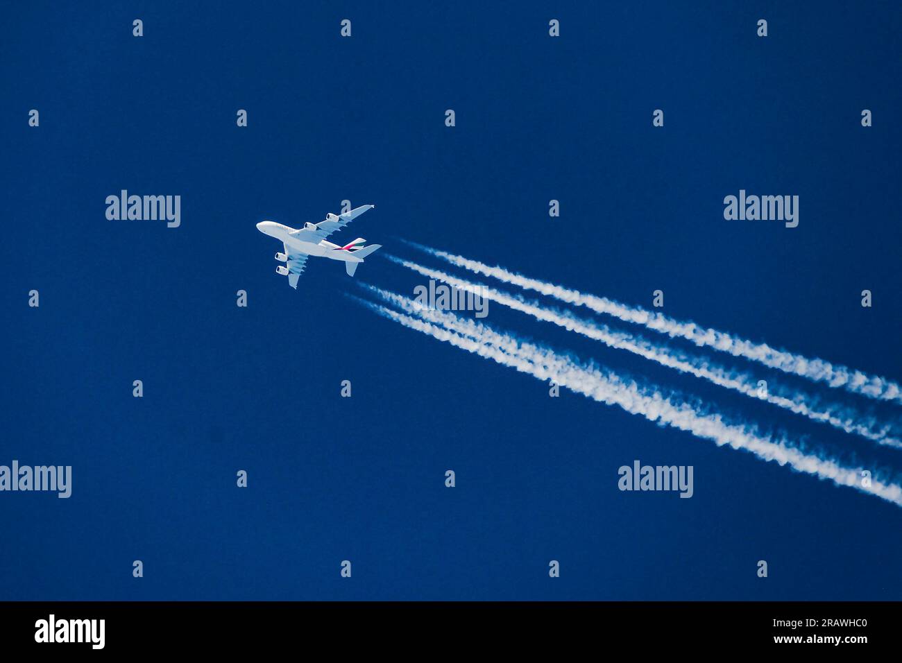 Sharp telephoto close-up of jet plane aircraft with contrails cruising ...