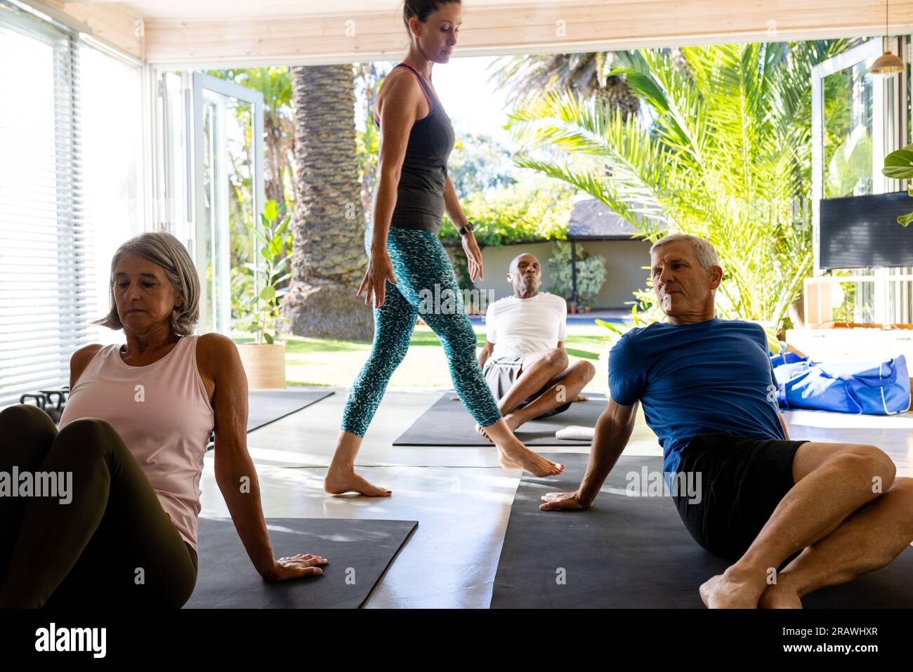 Senior diverse people with caucasian female teacher exercising in ...