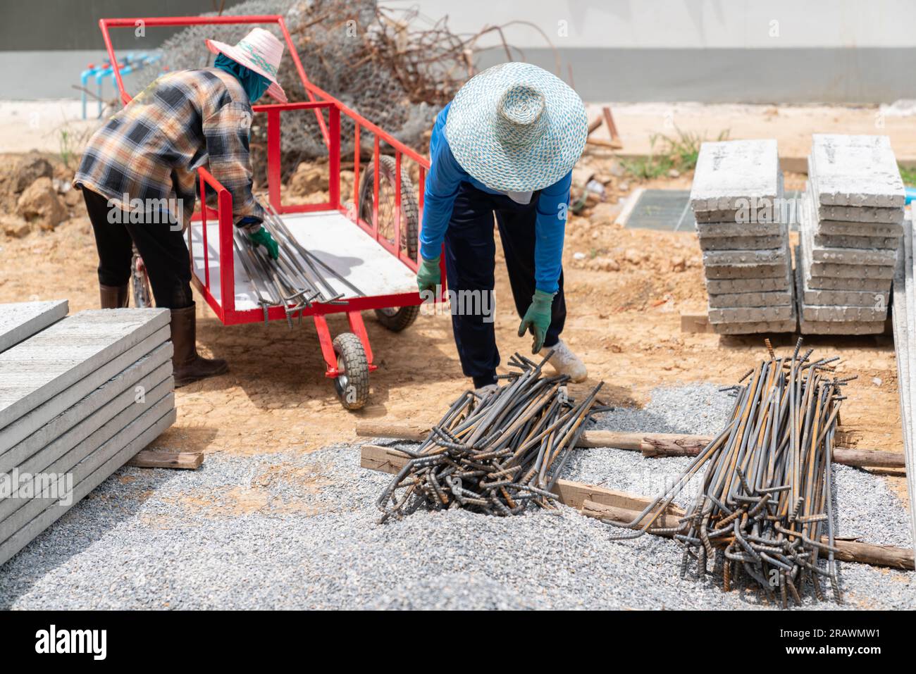 Construction workers are unloading steel rods from a cart in ...