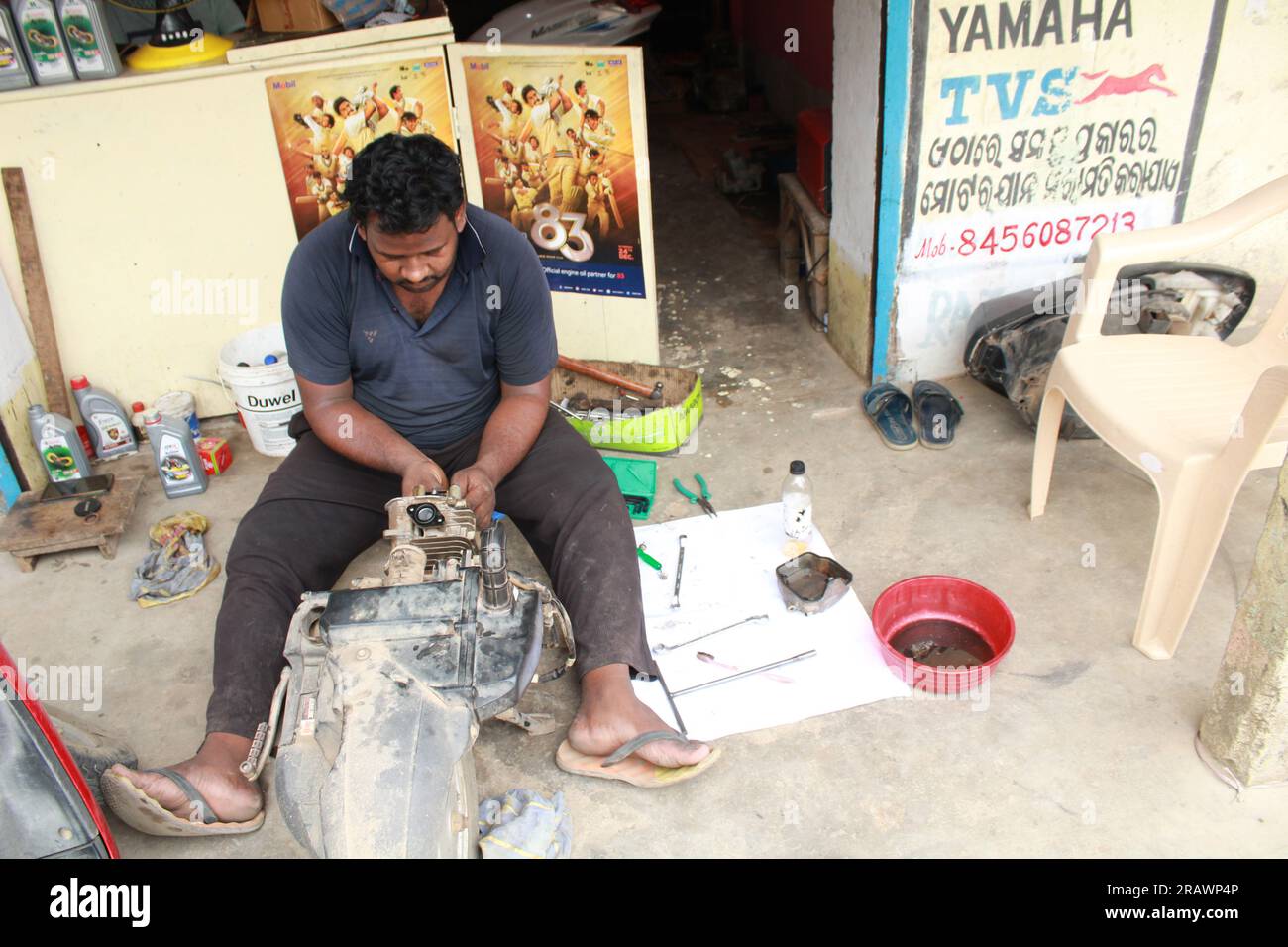 Mechanic Repairs a motercycle. A man works as a mechanic at a local ...
