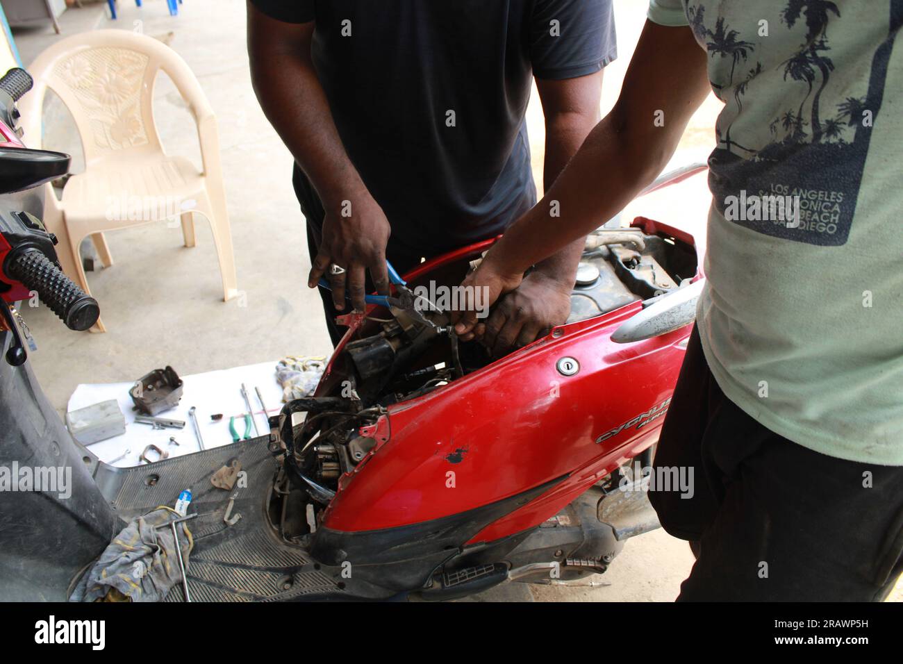 Mechanic Repairs a motercycle. A man works as a mechanic at a local ...