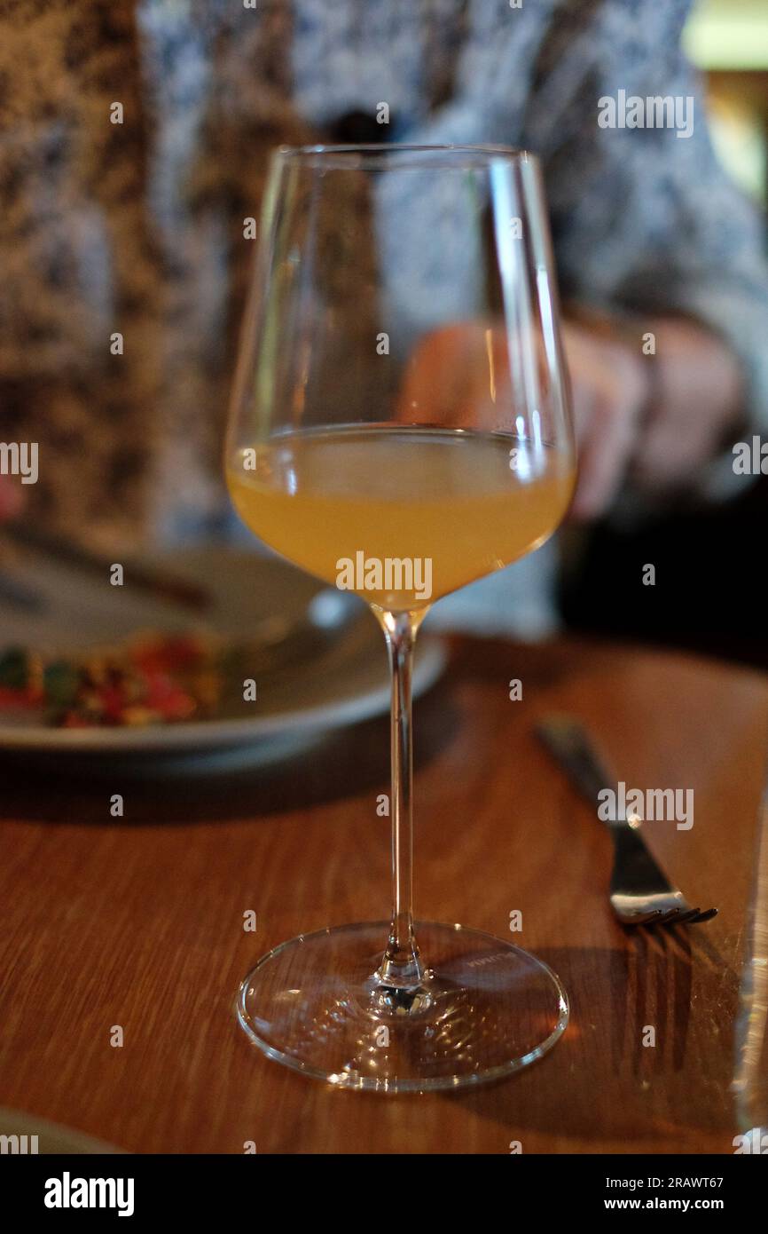 Non-alcoholic drinks and food pairing. Amber fruit juice in a large ...