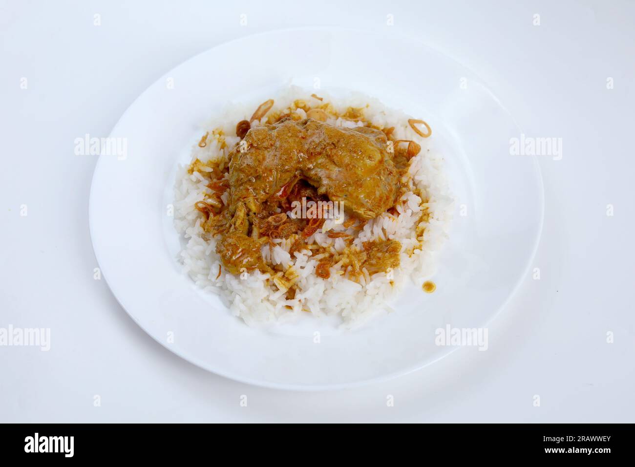 Top view a plate of warm white rice topped with chicken curry. Padang ...